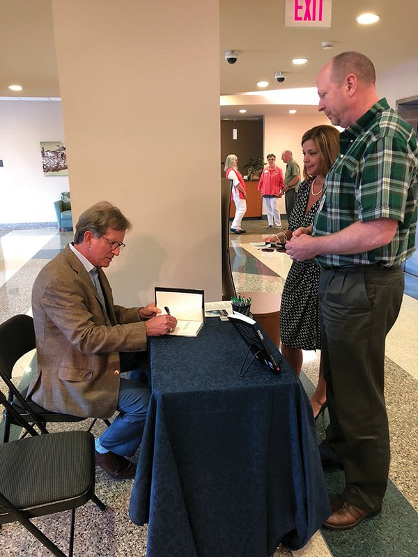 Autographing a copy | Magnolia Banner News