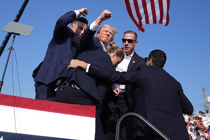 Amid chaos and gunfire, Trump raised his fist and projected a ...