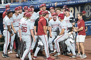 Arkansas players greet catcher Ryder Helfrick (right, batting helmet ...