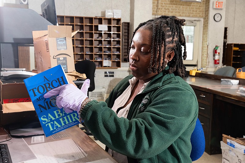 Alexis Page, an administrative assistant, scans mailed-in books for ...
