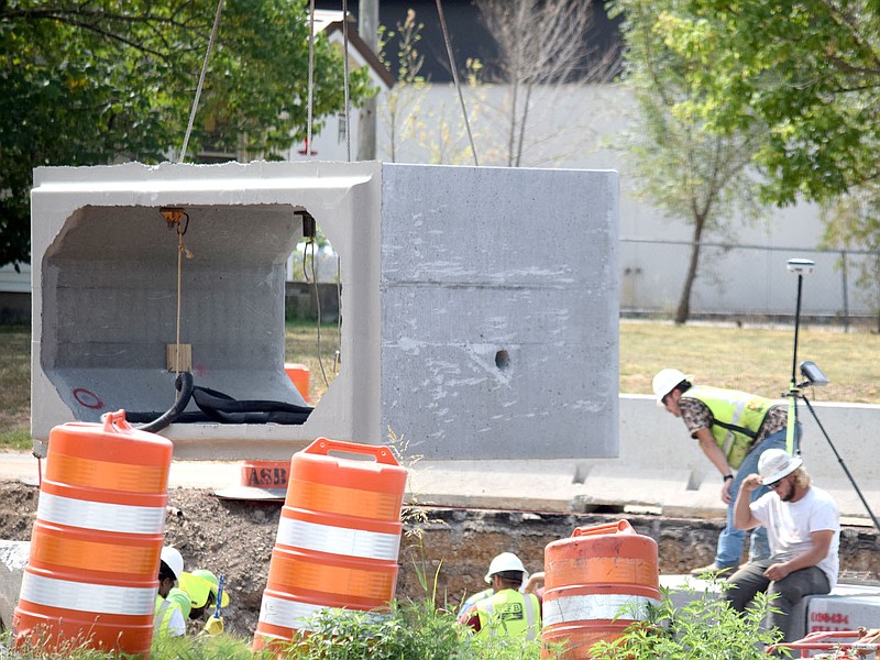 Concrete casing lowered into place to begin work on temporary bridge ...