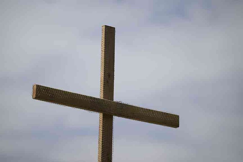 Members of burned LA church bear a cross through devastated ...
