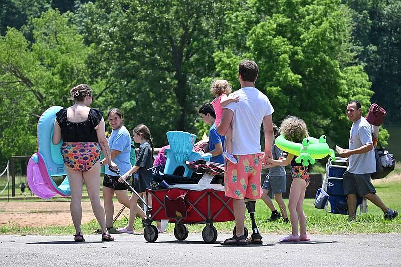 Guests arrive with swimming gear on Saturday during the free, one-day ...