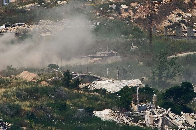 Israeli soldiers drive a tank in southern Lebanon as seen from northern ...